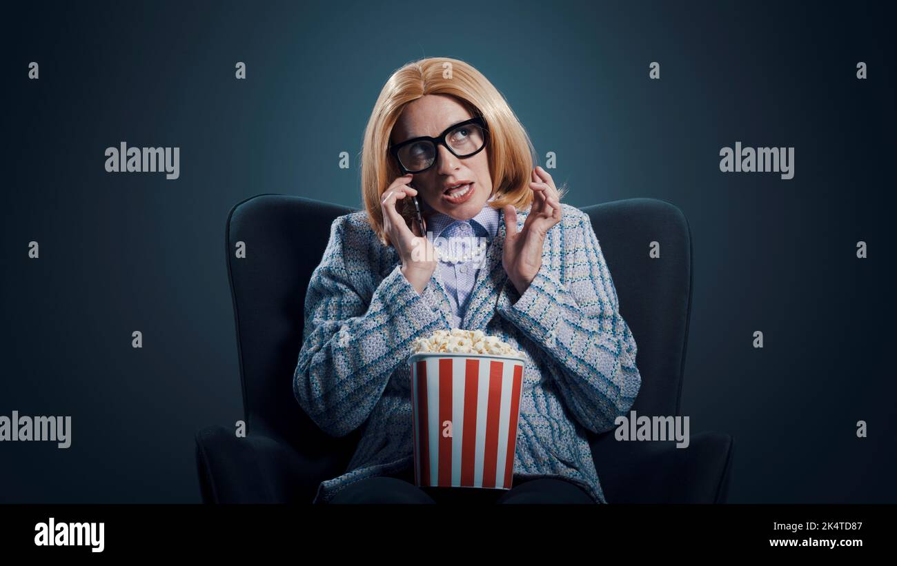 Funny rude woman talking with her smartphone at the movie theater Stock ...