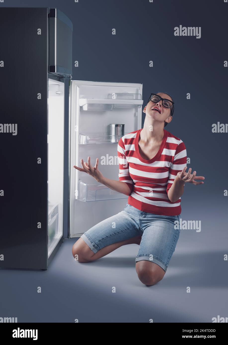 Desperate crying woman and empty fridge, she is hungry but she has no ...