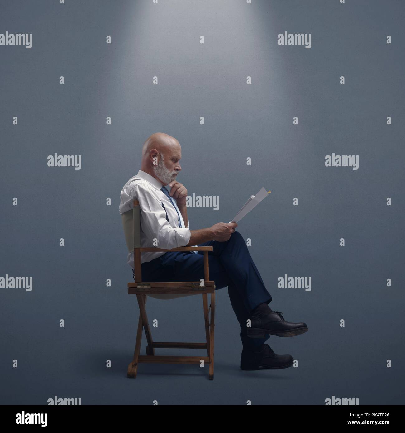 Professional actor sitting on a director's chair and reading a ...