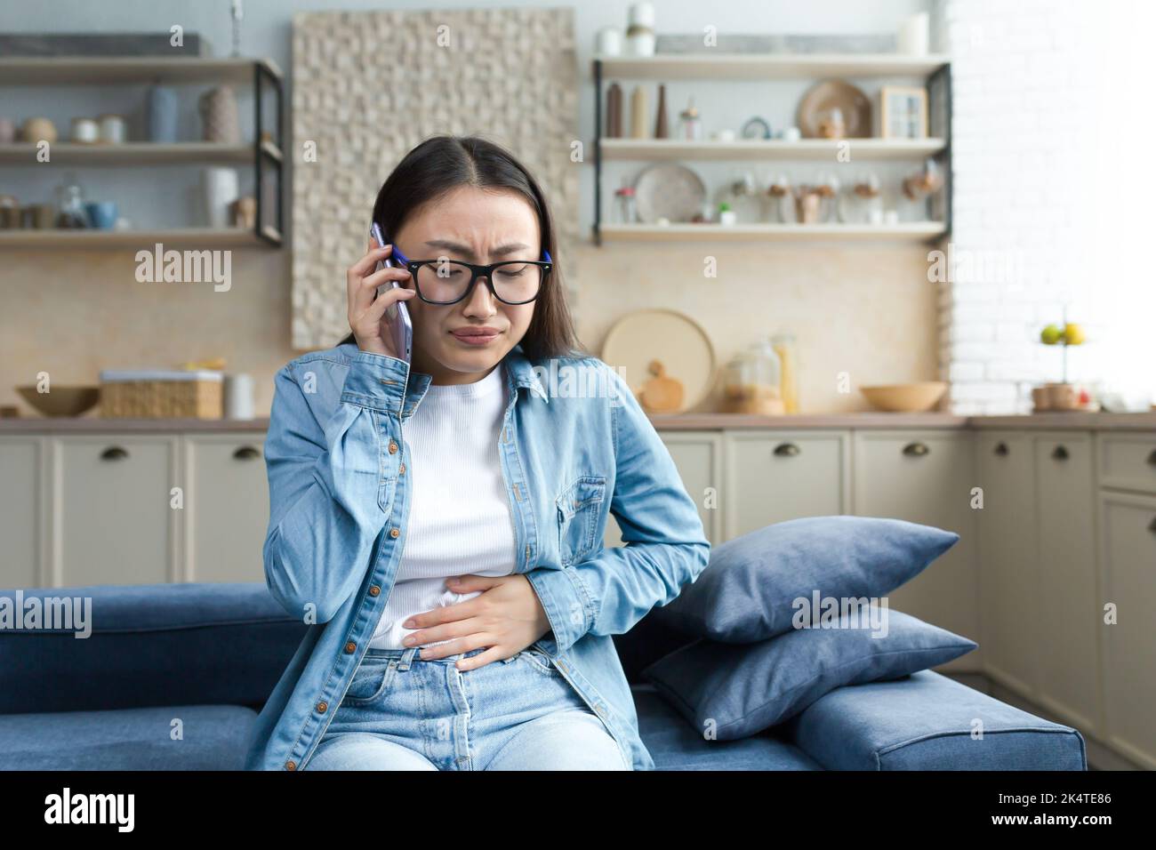 Sick asian woman at home, woman sitting on sofa and having severe ...