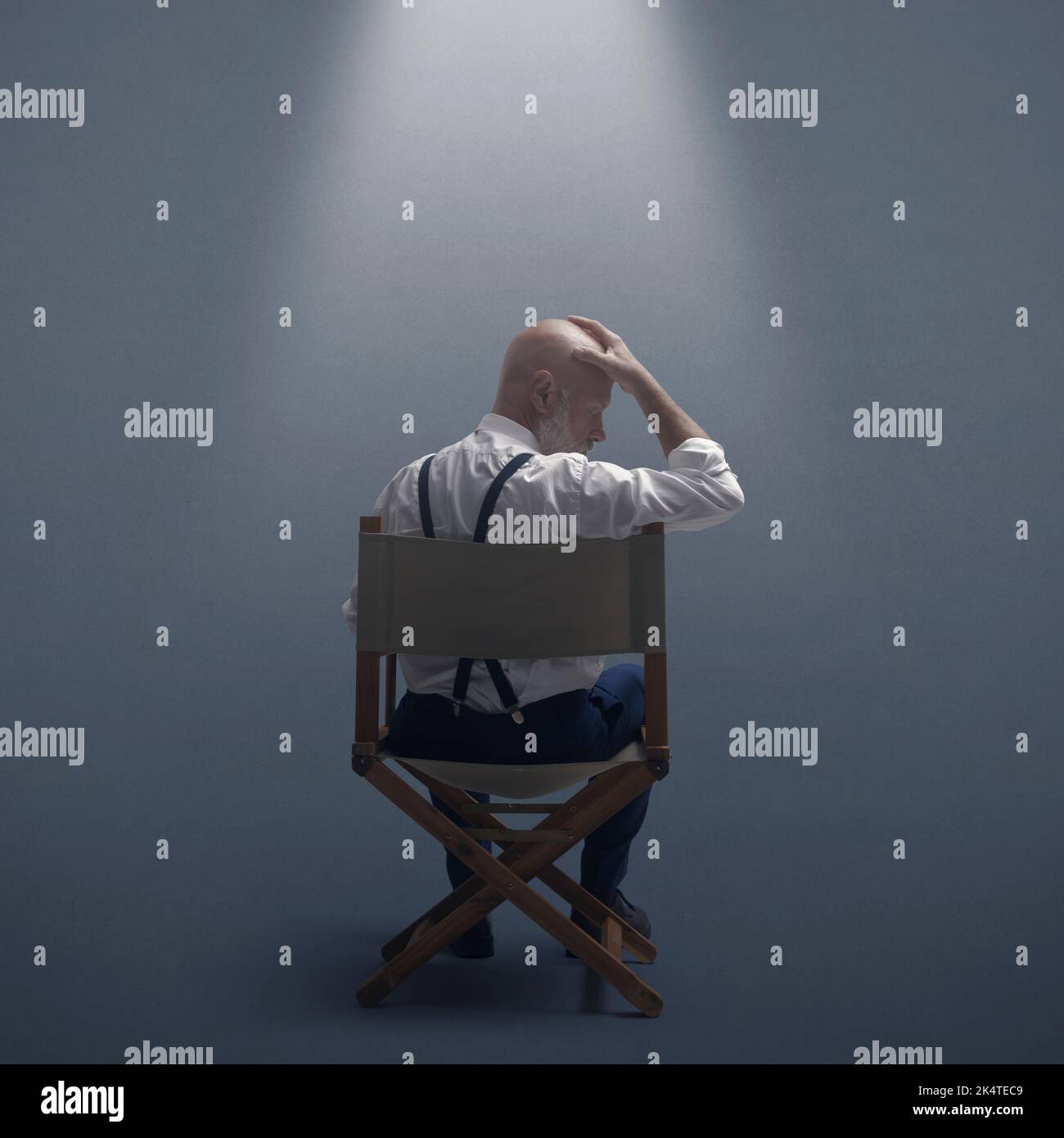 Disappointed filmmaker sitting on the director's chair and touching his ...