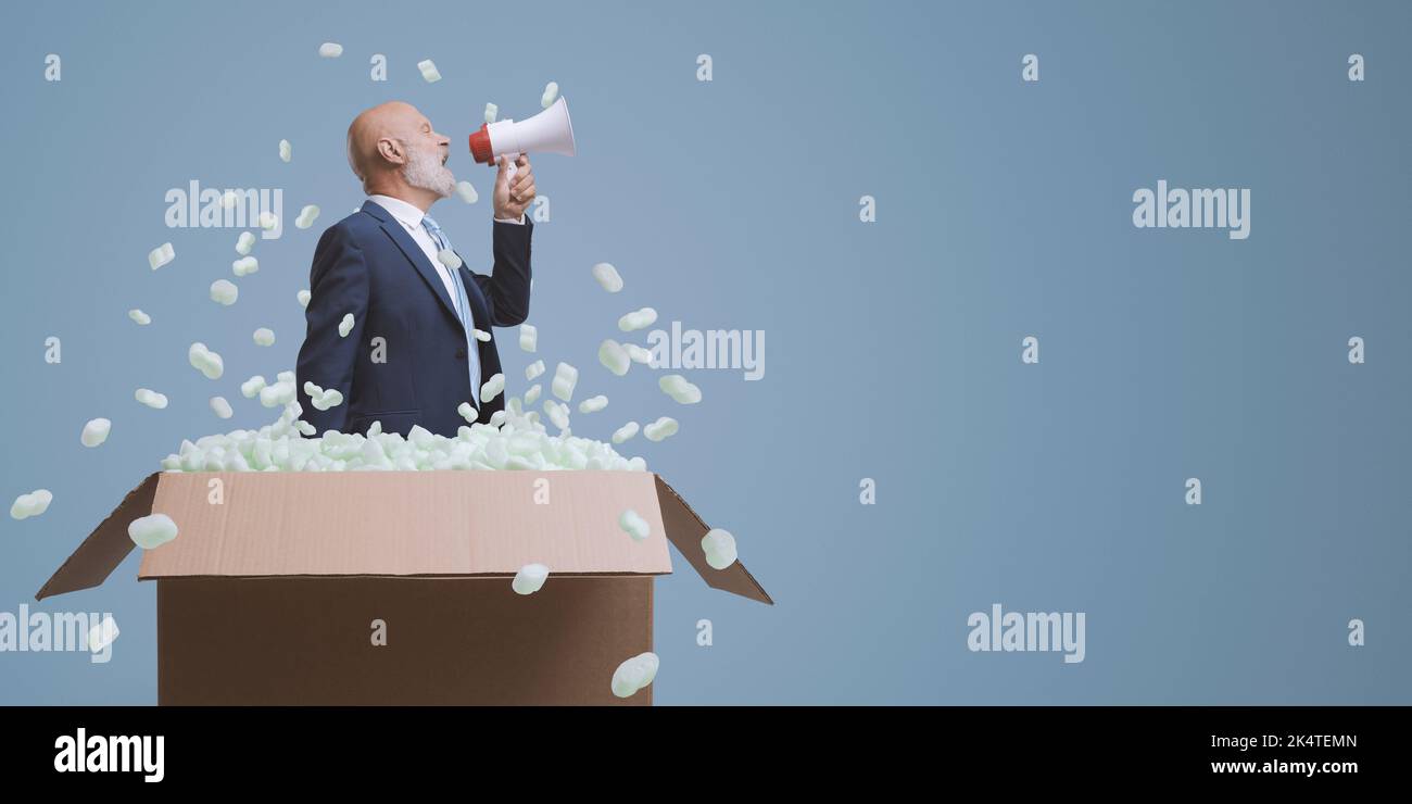Businessman shouting with a megaphone in a delivery box, business and ...