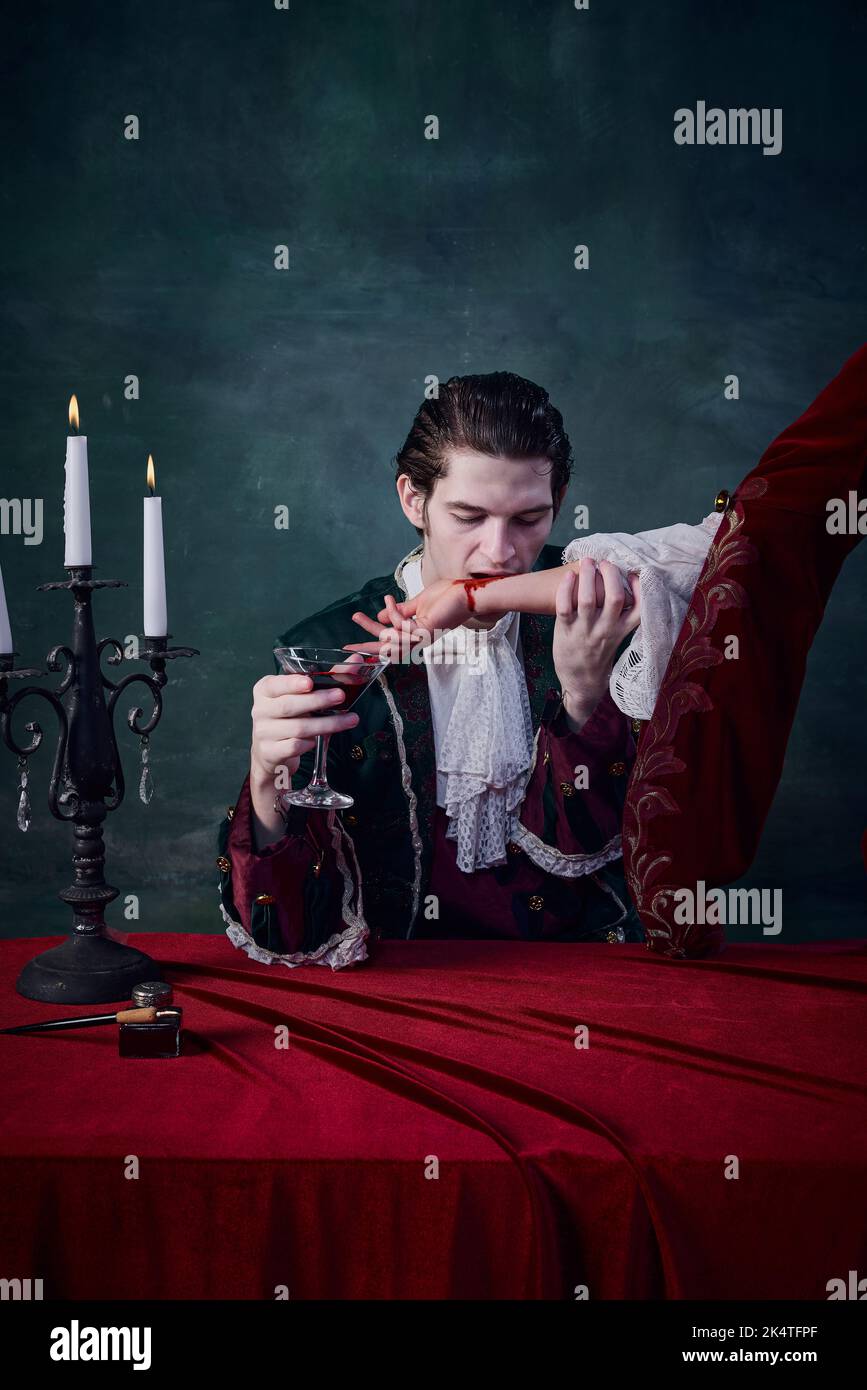 Portrait of endlessly young man in image of vampire drinking blood from ...