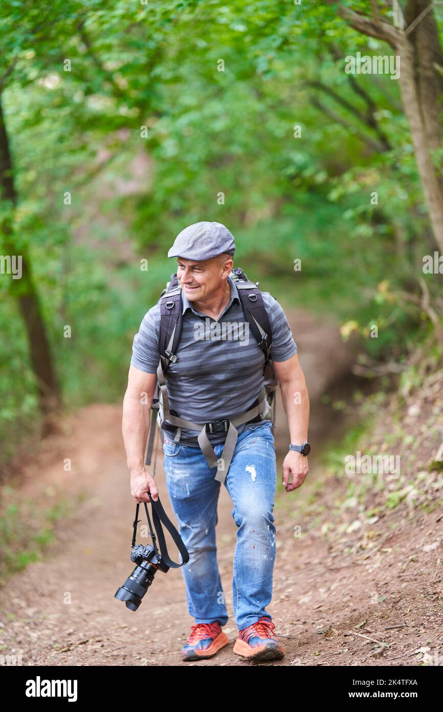 Professional travel and nature photographer hiking in the forests with ...
