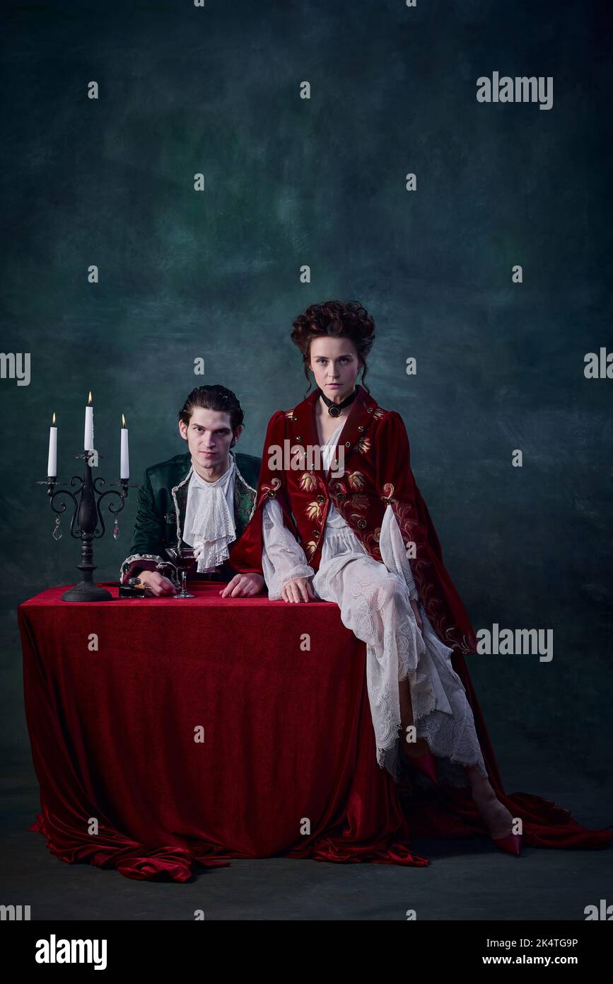 Portrait of mysterious woman and man in medieval costumes sitting over ...