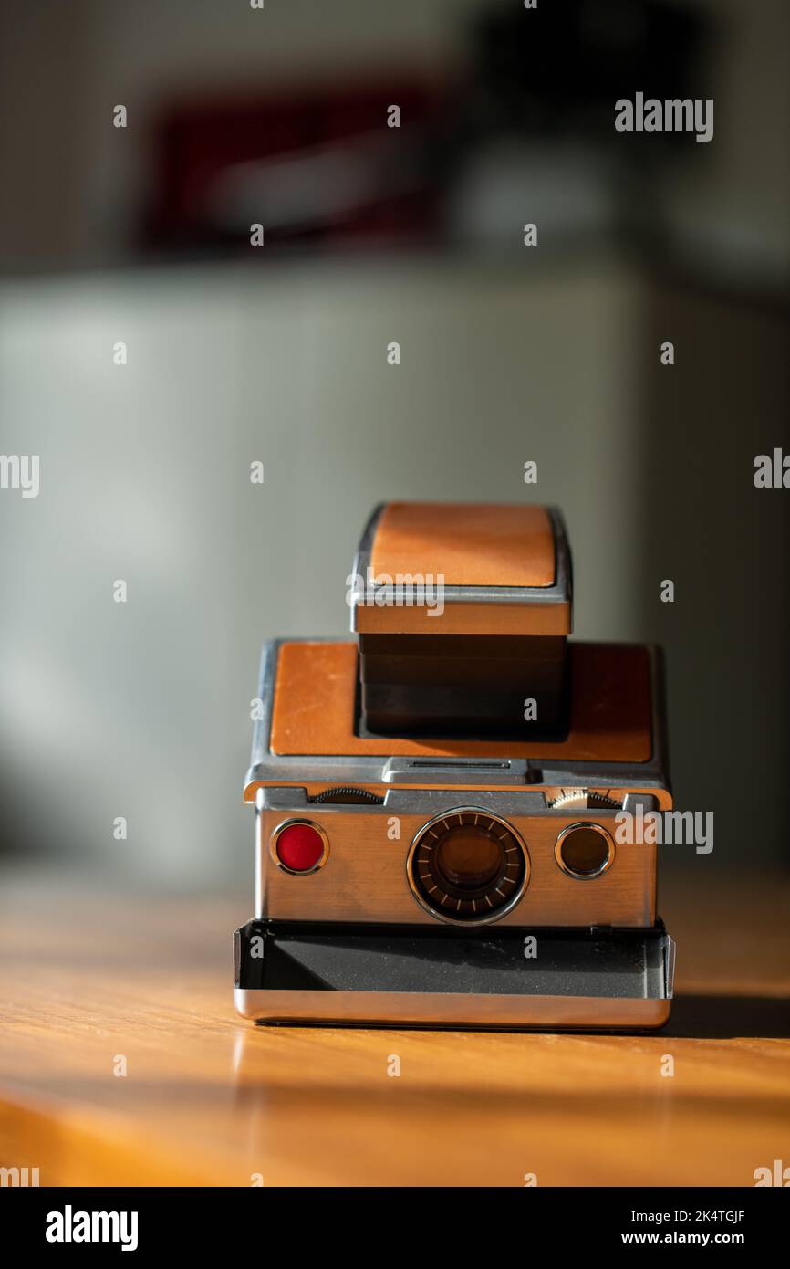 Retro instant camera on a midcentury wooden desk. Polaroid Stock Photo ...