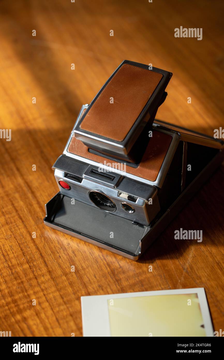 Retro instant camera on a midcentury wooden desk. Polaroid Stock Photo ...