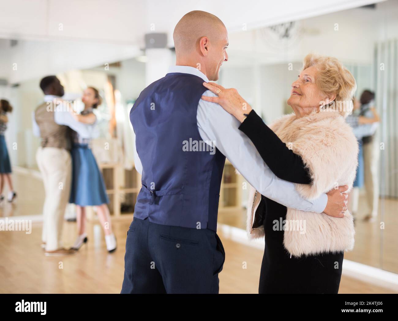 Elderly woman learning ballroom dancing movements in pair Stock Photo ...