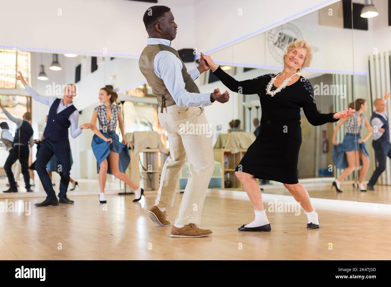 Man and elderly woman performing jazz dance in dancing room Stock Photo ...