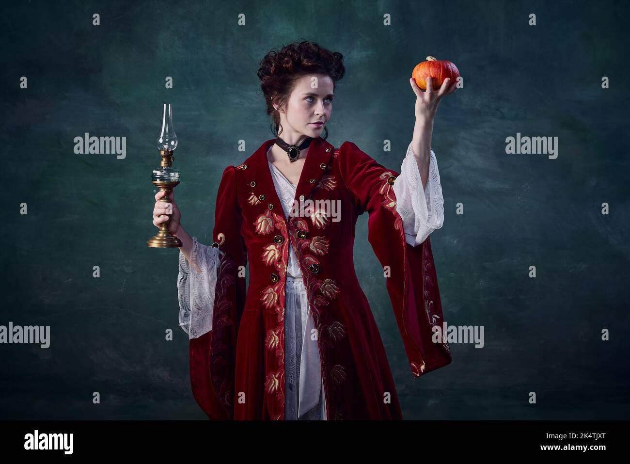 Portrait of beautiful woman in image of medieval vampire holding candle ...