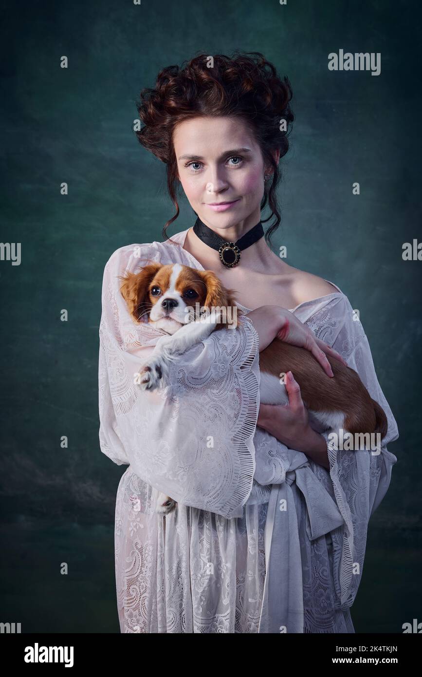 Young smiling woman with pale skin and blushing cheeks holding little ...