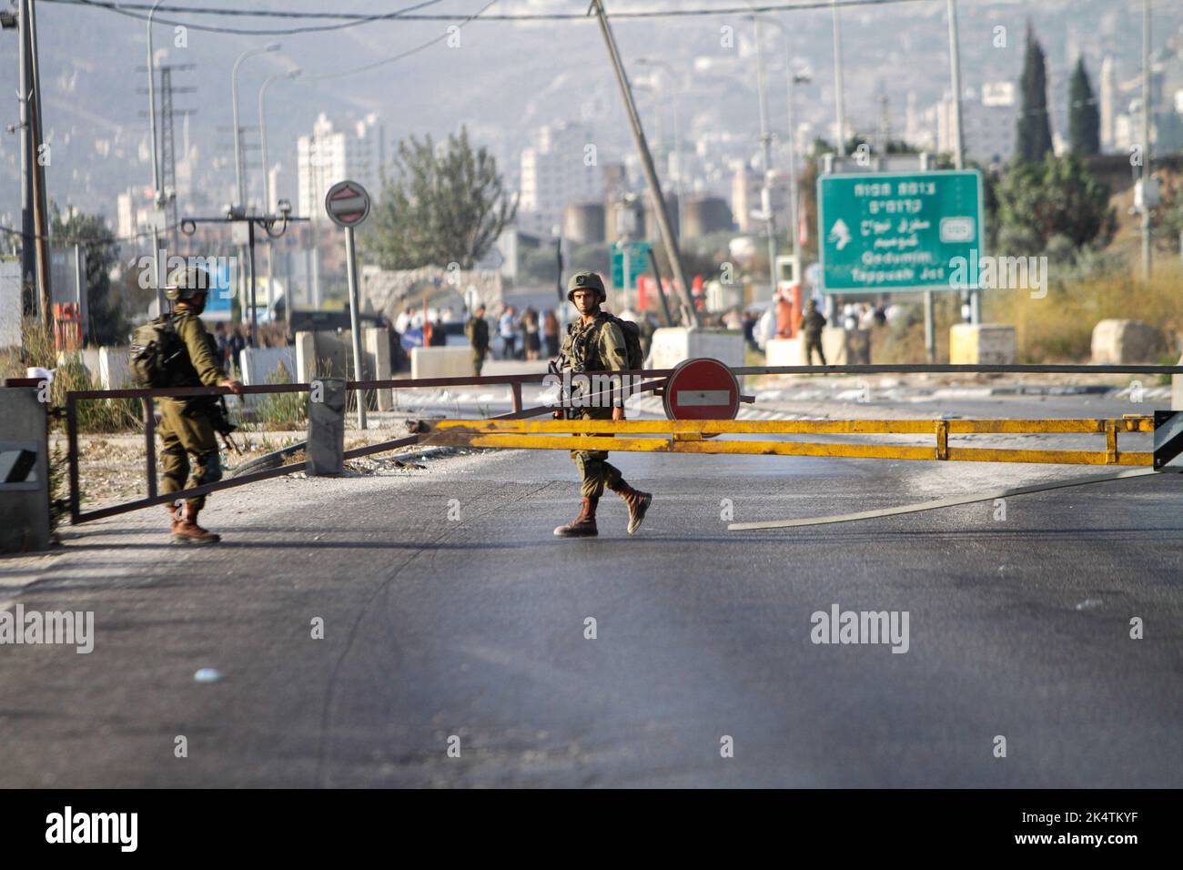 Israeli soldiers guard against Palestinians while Jewish settlers block ...