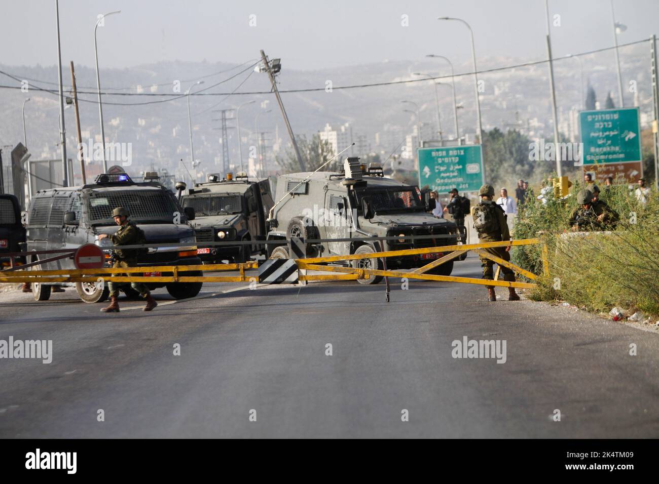 Israeli soldiers guard against Palestinians while Jewish settlers block ...