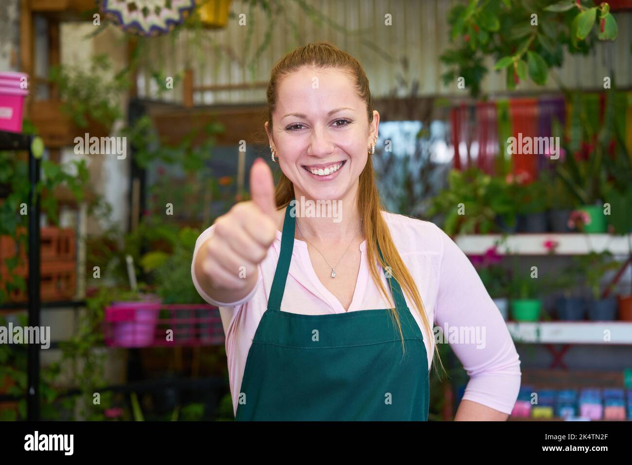 Happy smiling female florist showing thumbs up as founder in startup ...