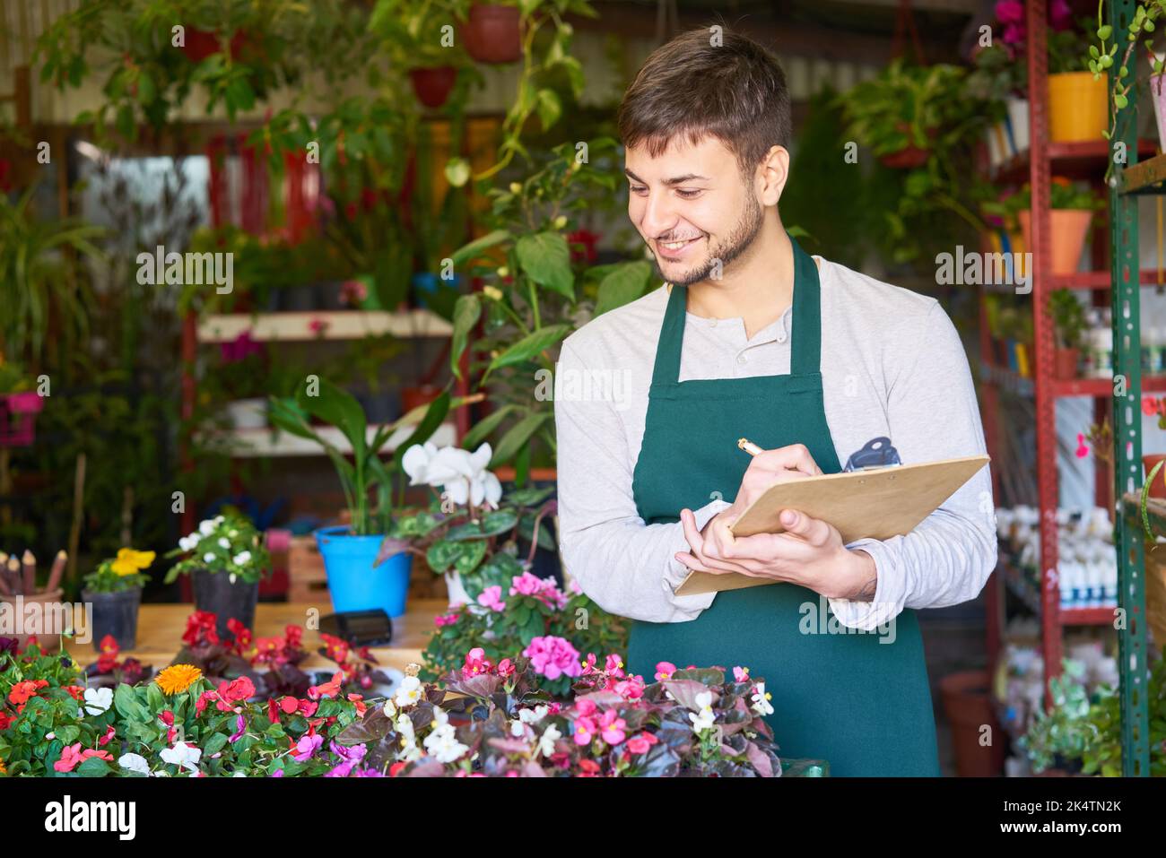 Florist with clipboard and checklist doing inventory or quality control ...