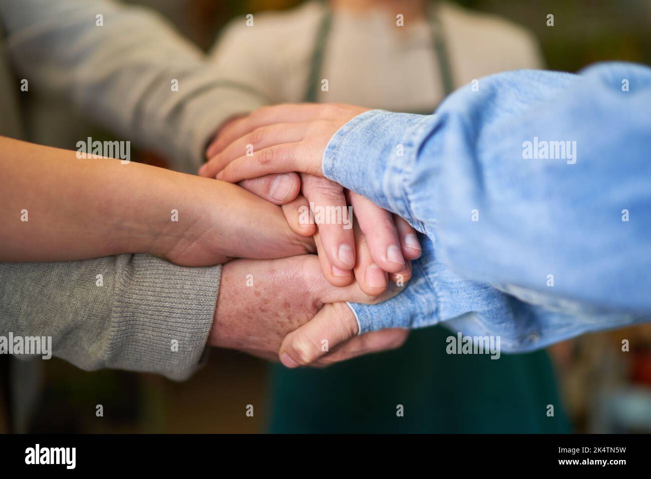 People stacking hands in team building workshop as concept for ...