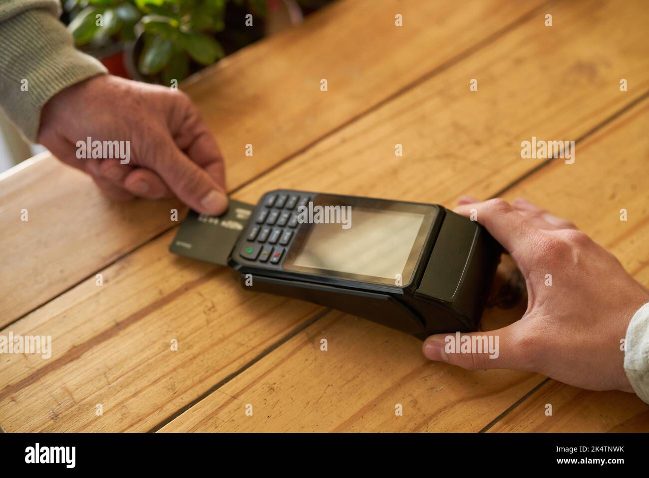 Hand puts credit card in the reader at the checkout for cashless ...