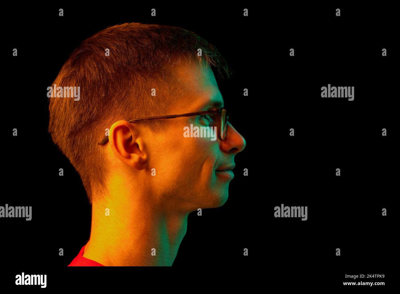 Portrait of young man in glasses posing, looking away isolated over ...