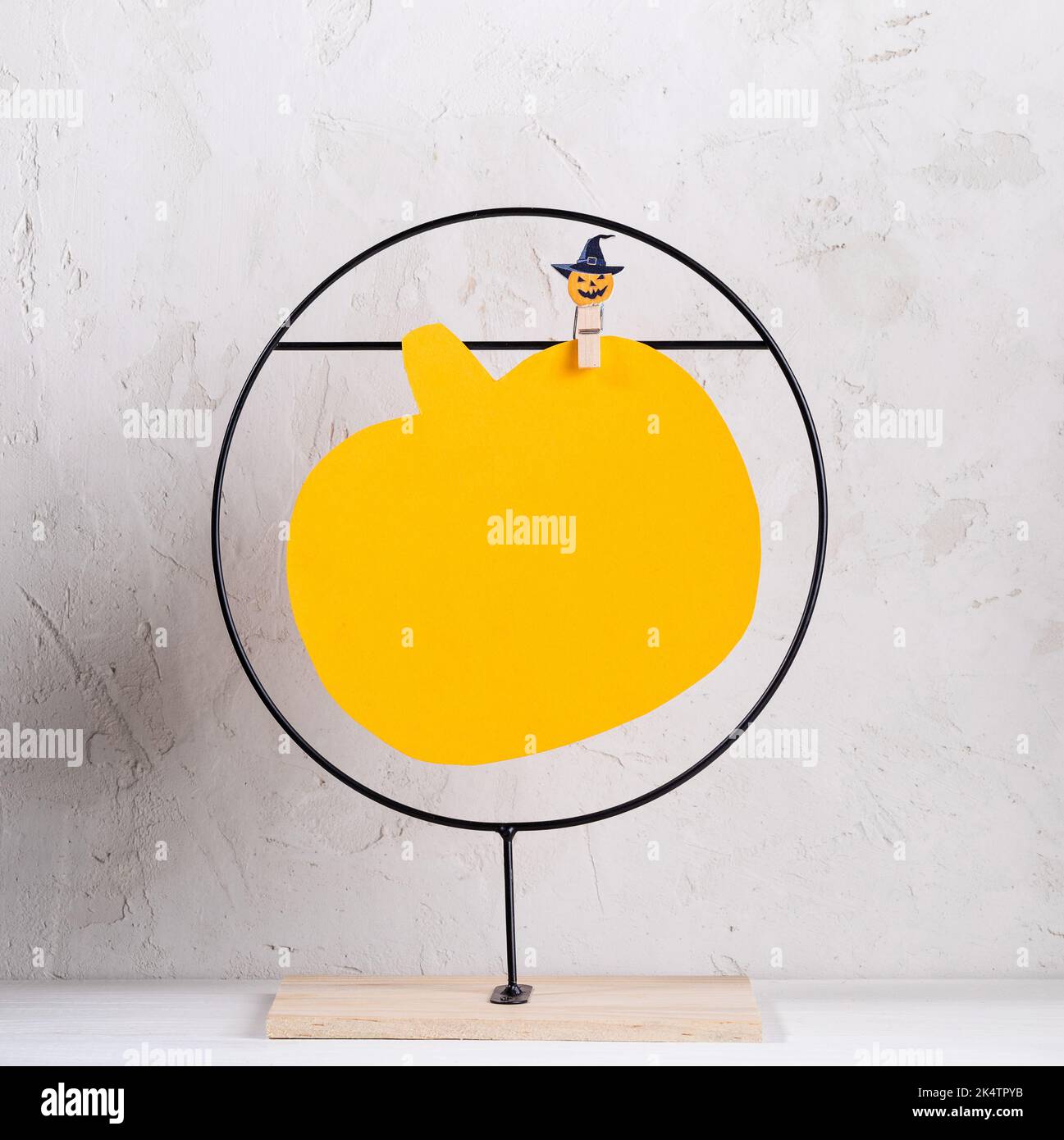 Minimal Halloween image. Empty yellow sheet in form of pumpkin fixed on ...