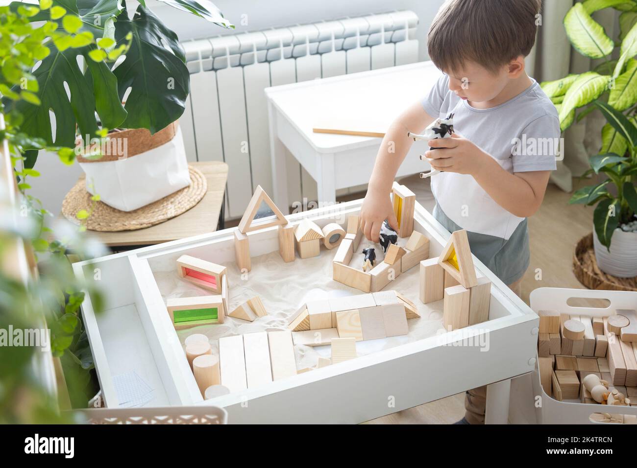 Cute boy kid playing sensory box kinetic sand table with Montessori ...