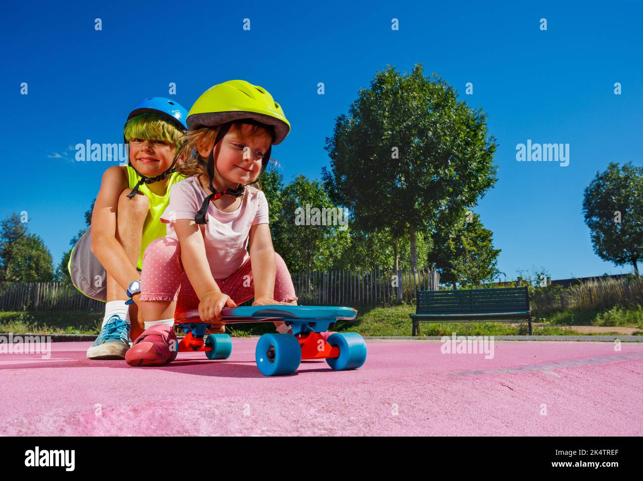 Big brother play with little girl push skate at the park Stock Photo ...