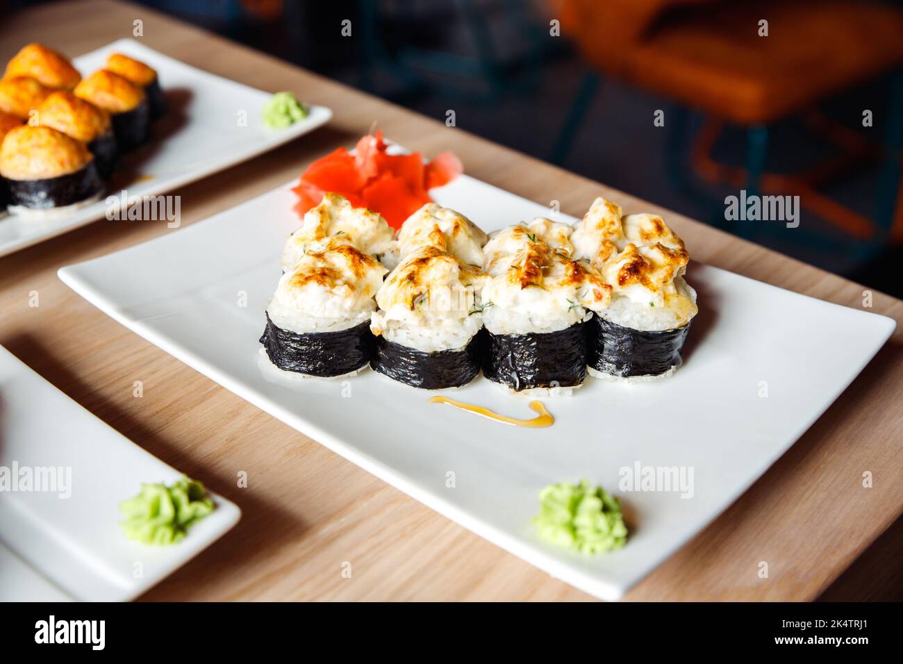 Baked Maki sushi, baked rolls on white rectangular plate. Chicken, rice ...