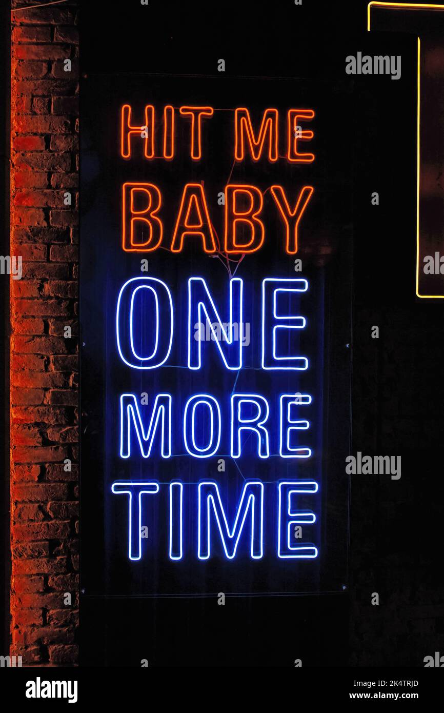 Blue and Red neon light lettering "Hit me baby one more time" in dark ...