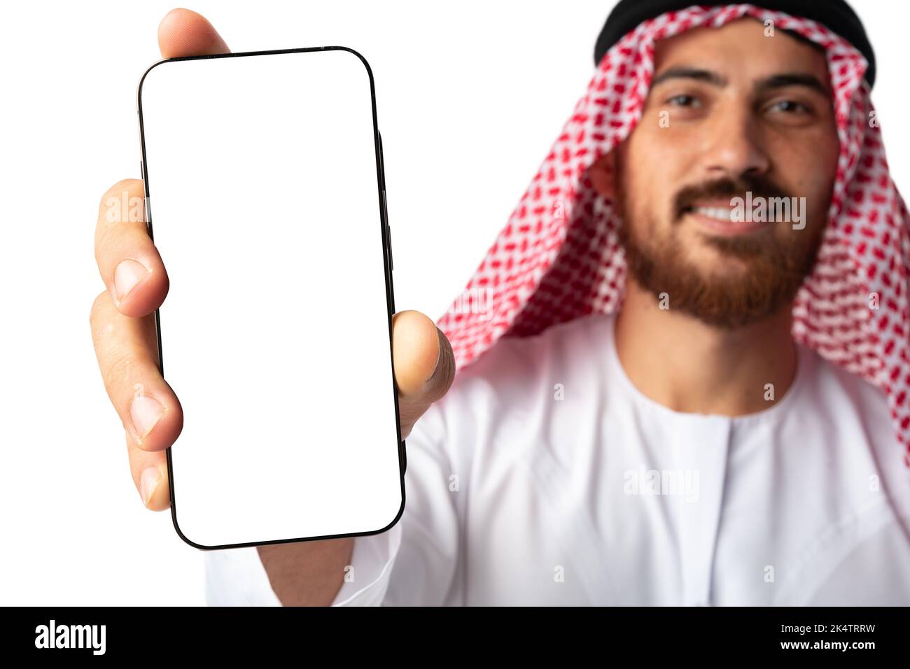 Young Arab muslim man in traditional clothes showing mobile phone ...