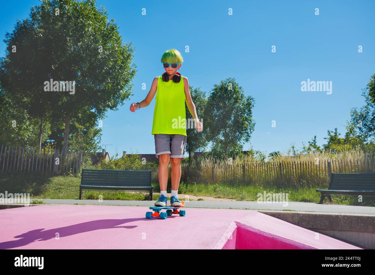 Boy with green hair ride skateboard at skatepark wear sunglasses Stock ...