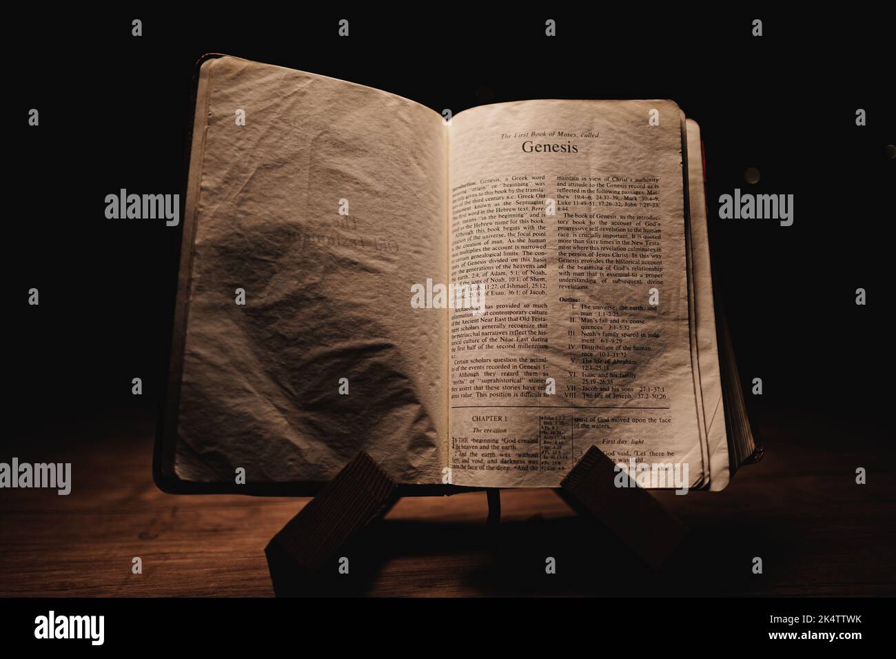 An open bible placed on a wooden book stand with a dark background ...