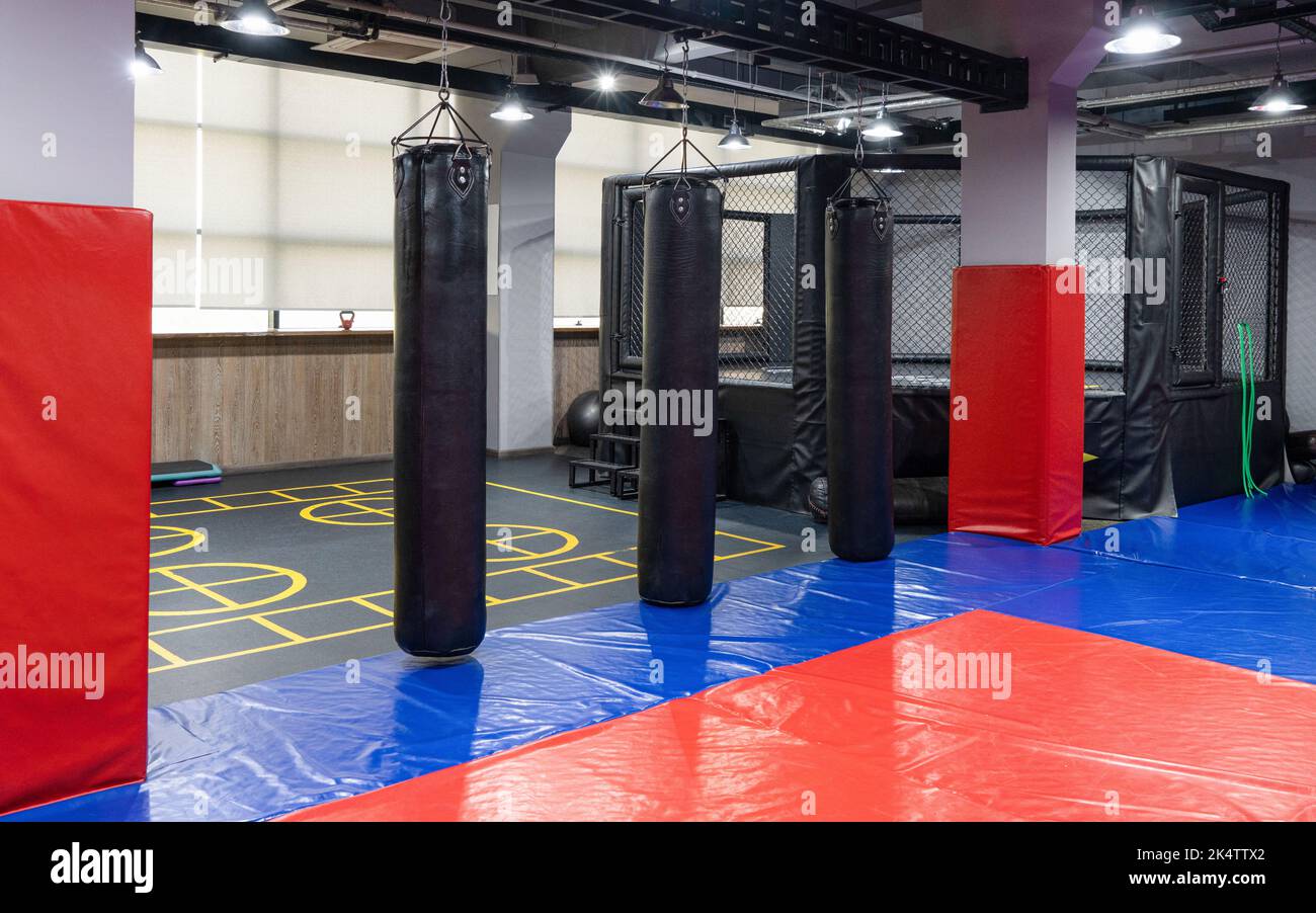 An octagonal kickboxing cage with boxing bags in the sports complex ...