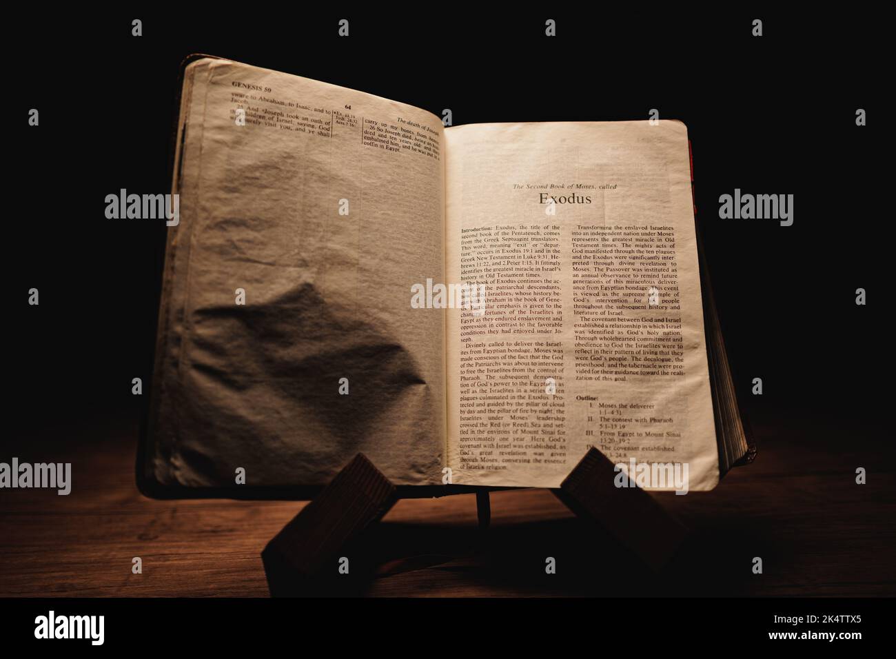 An open bible placed on a wooden book stand with a dark background ...