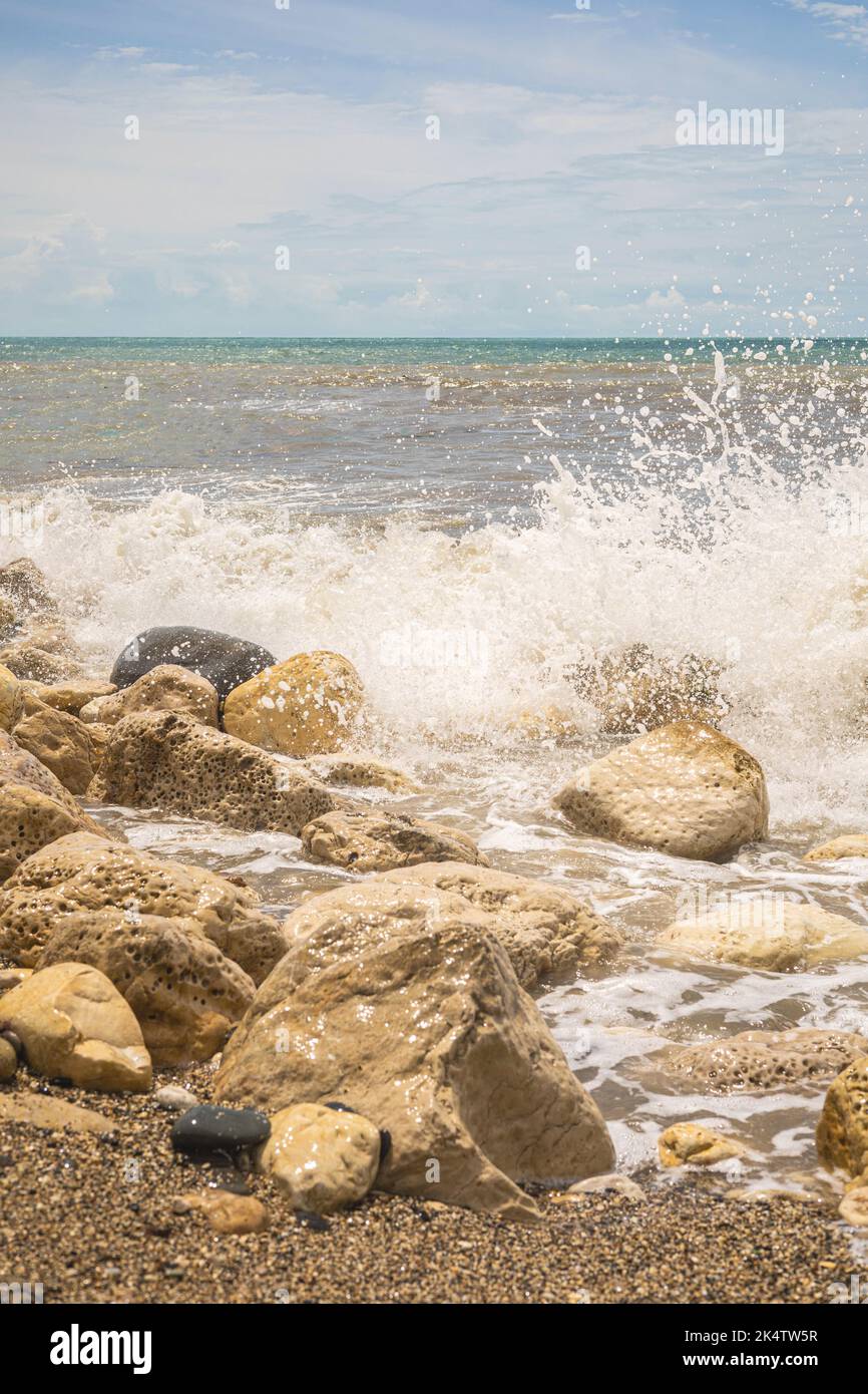 Empty dock pier sunny beach sea wave splash water cobblestones rock ...