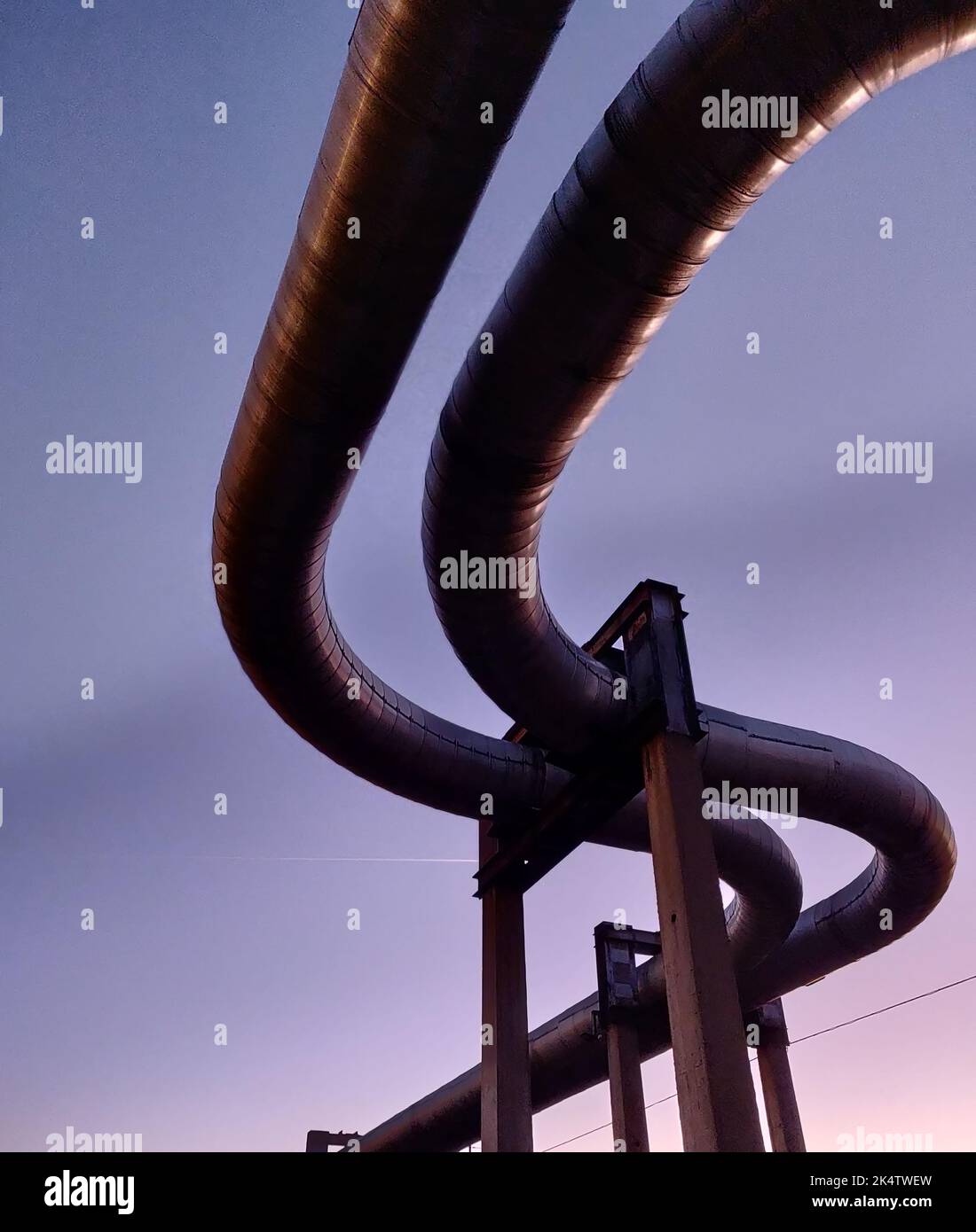 A low angle of live steam pipeline fixed above the ground with huge ...