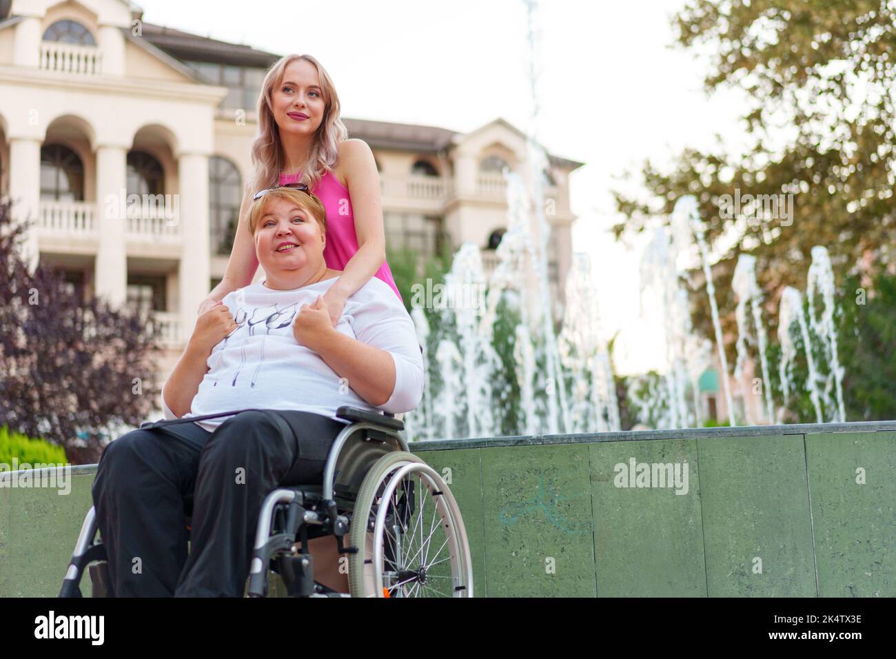 Young daughter taking care of her mother with disability sitting in ...