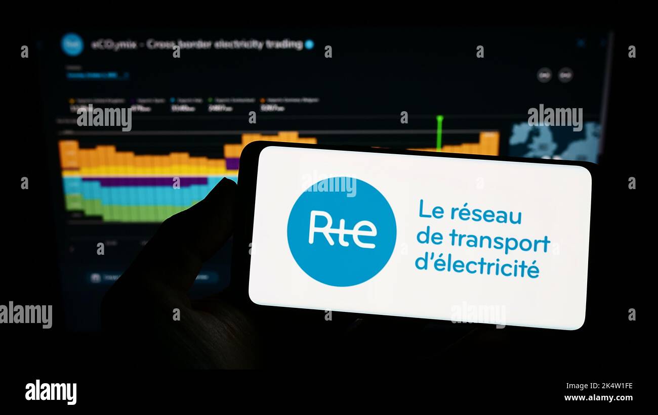 Person holding smartphone with logo of Reseau de Transport d ...