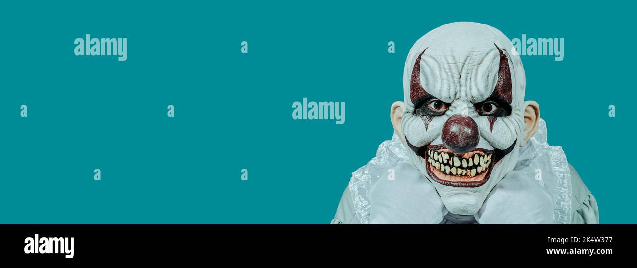 evil clown, wearing gloves and a costume with a white ruff, staring at ...