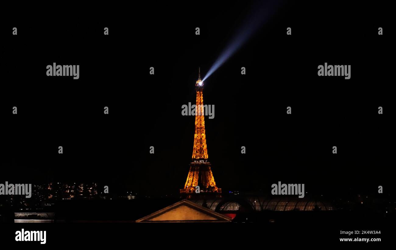 An aerial view of illuminated Eiffel Tower at night in Paris, France on black sky background ...