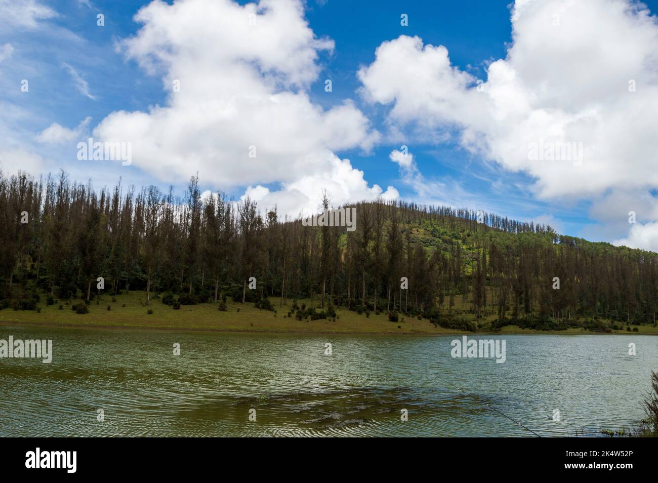 Scenic Ooty Lake, blue and white sky, reflection visible in water ...