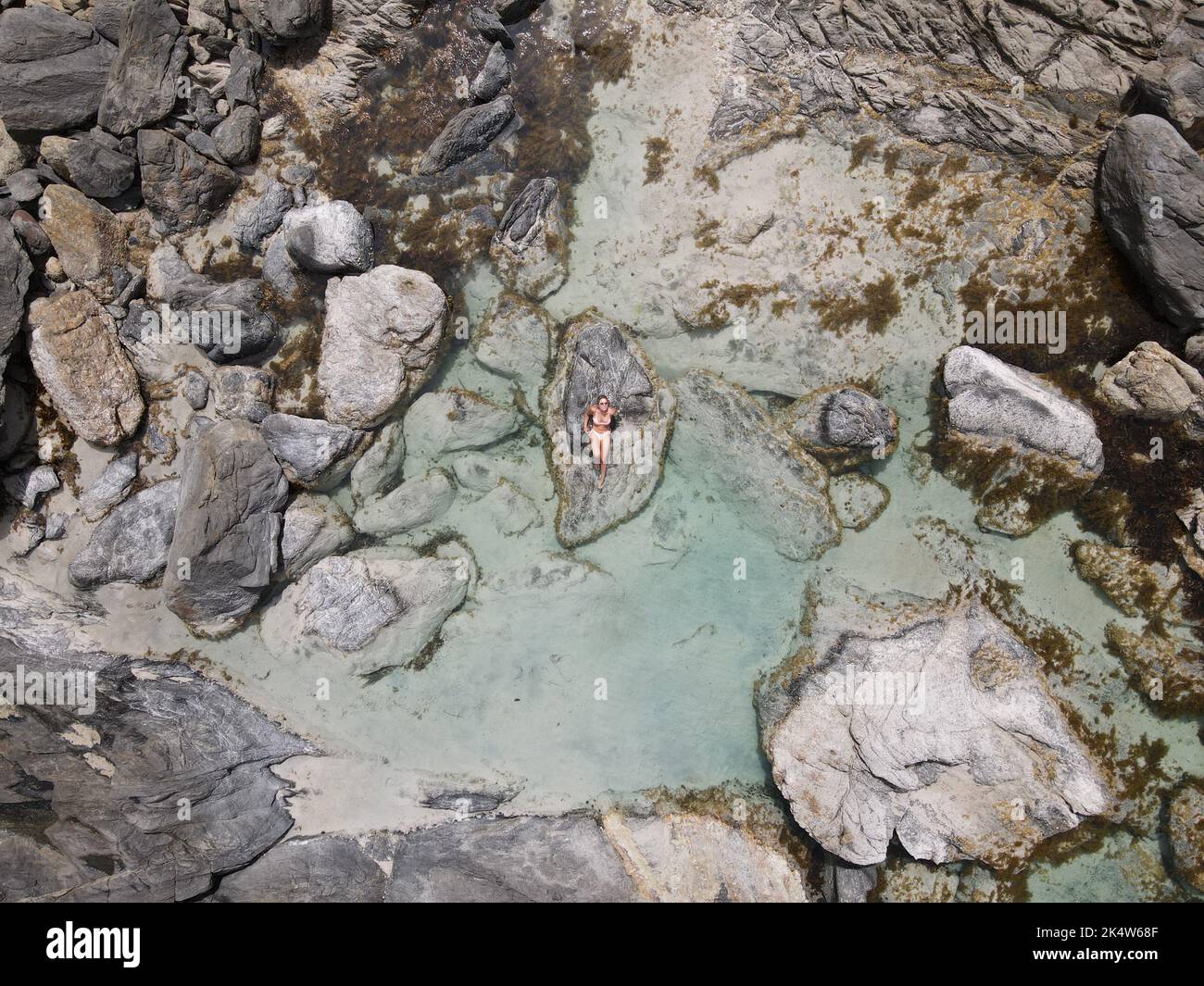 Woman resting on rocky stone hi-res stock photography and images - Alamy