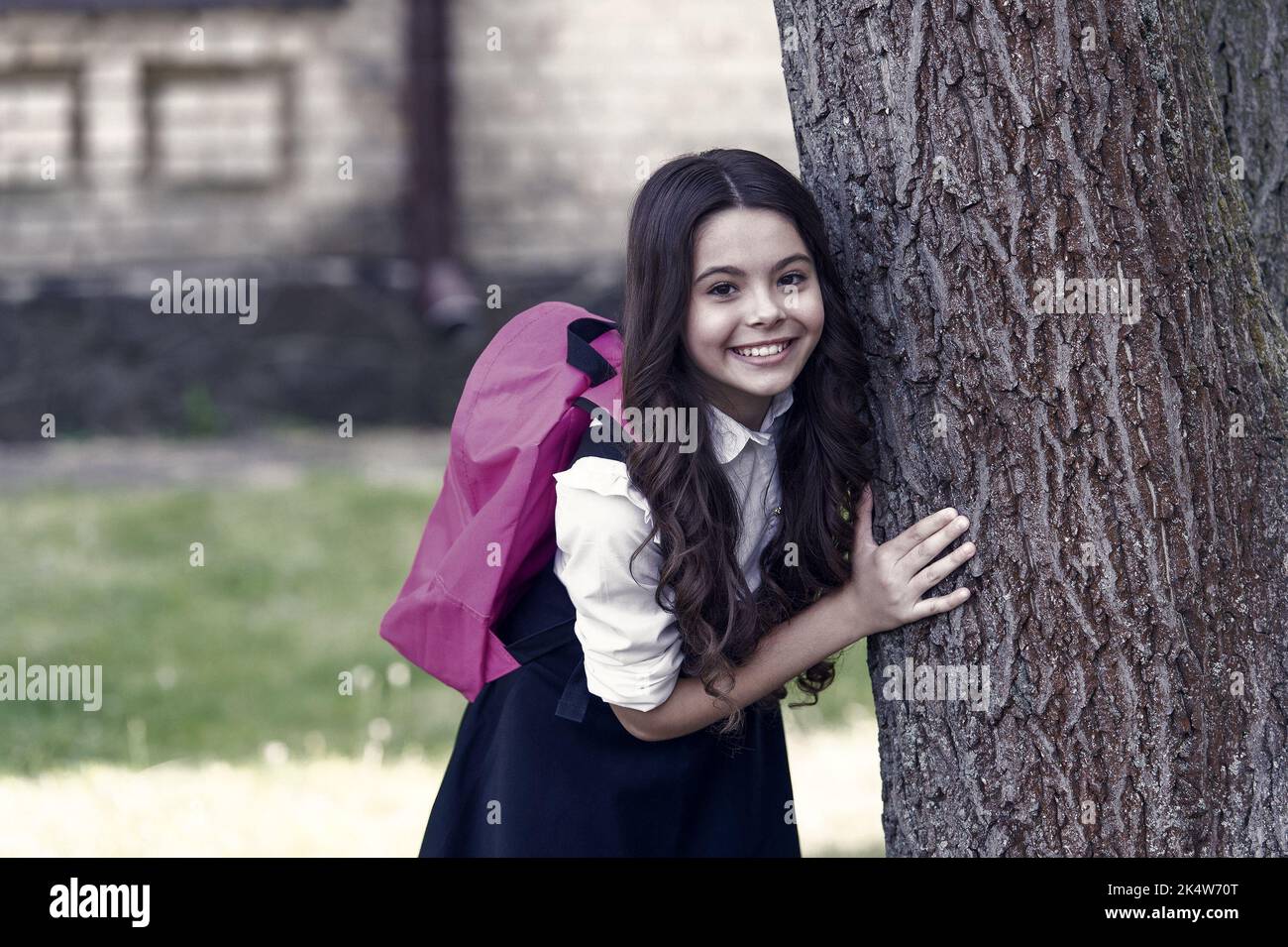 Early autumn. Happy child in uniform stand at tree. Back to school ...