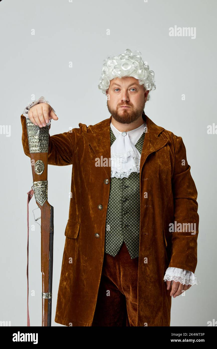 Studio shot of young man in image of medieval person in vintage brown ...