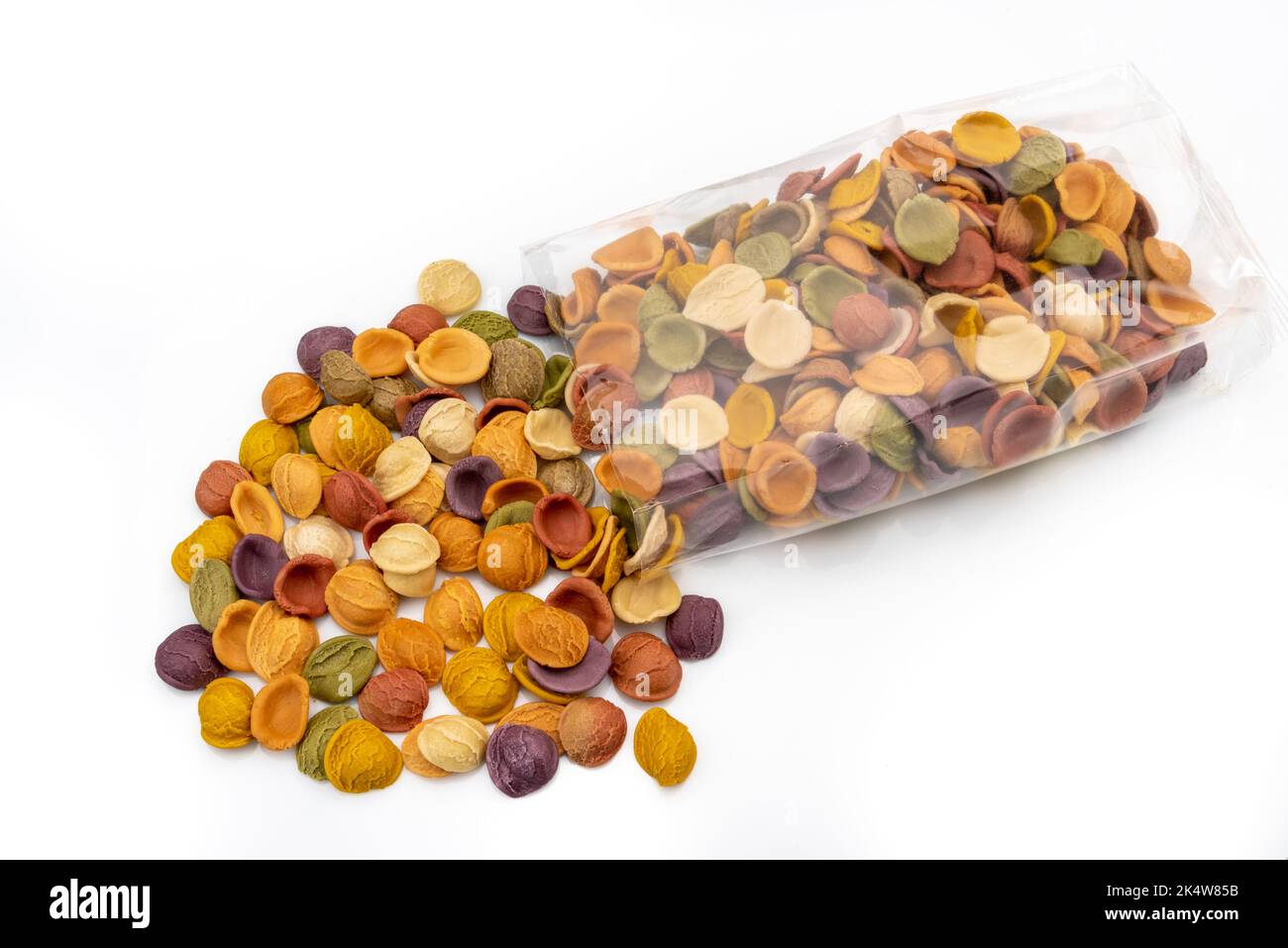 Colored pasta orecchiette that come out of transparent bag, italian ...