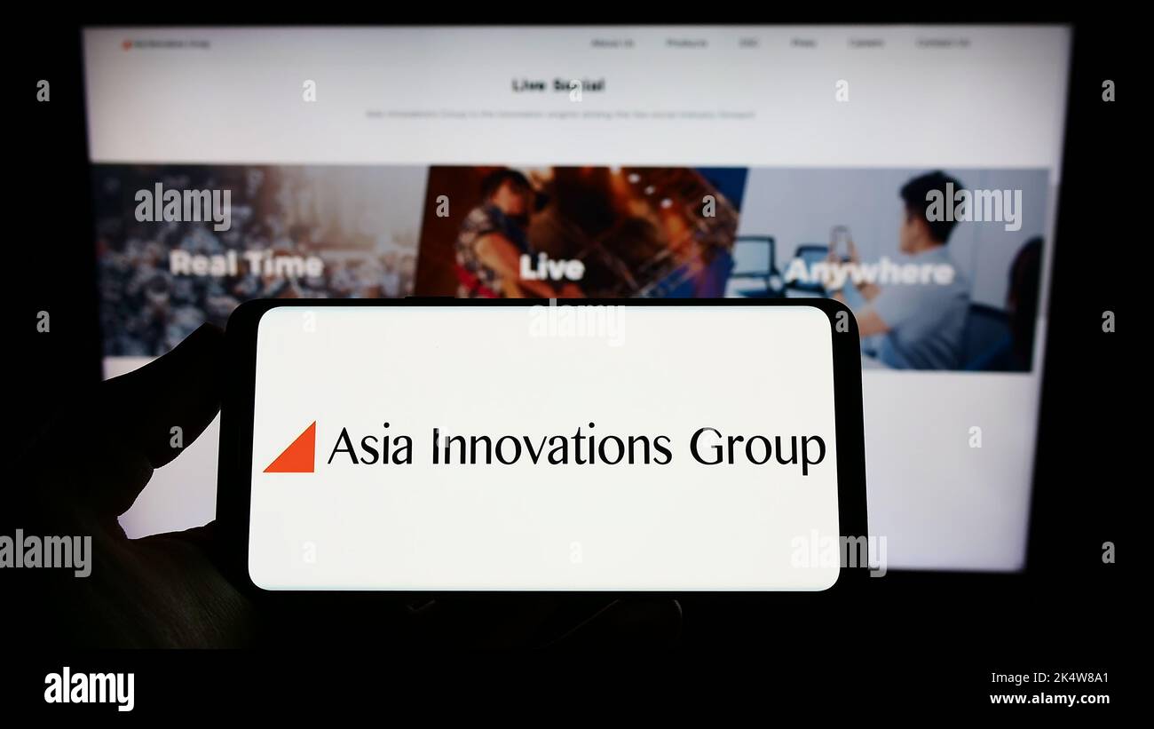 Person holding smartphone with logo of Internet company Asia ...