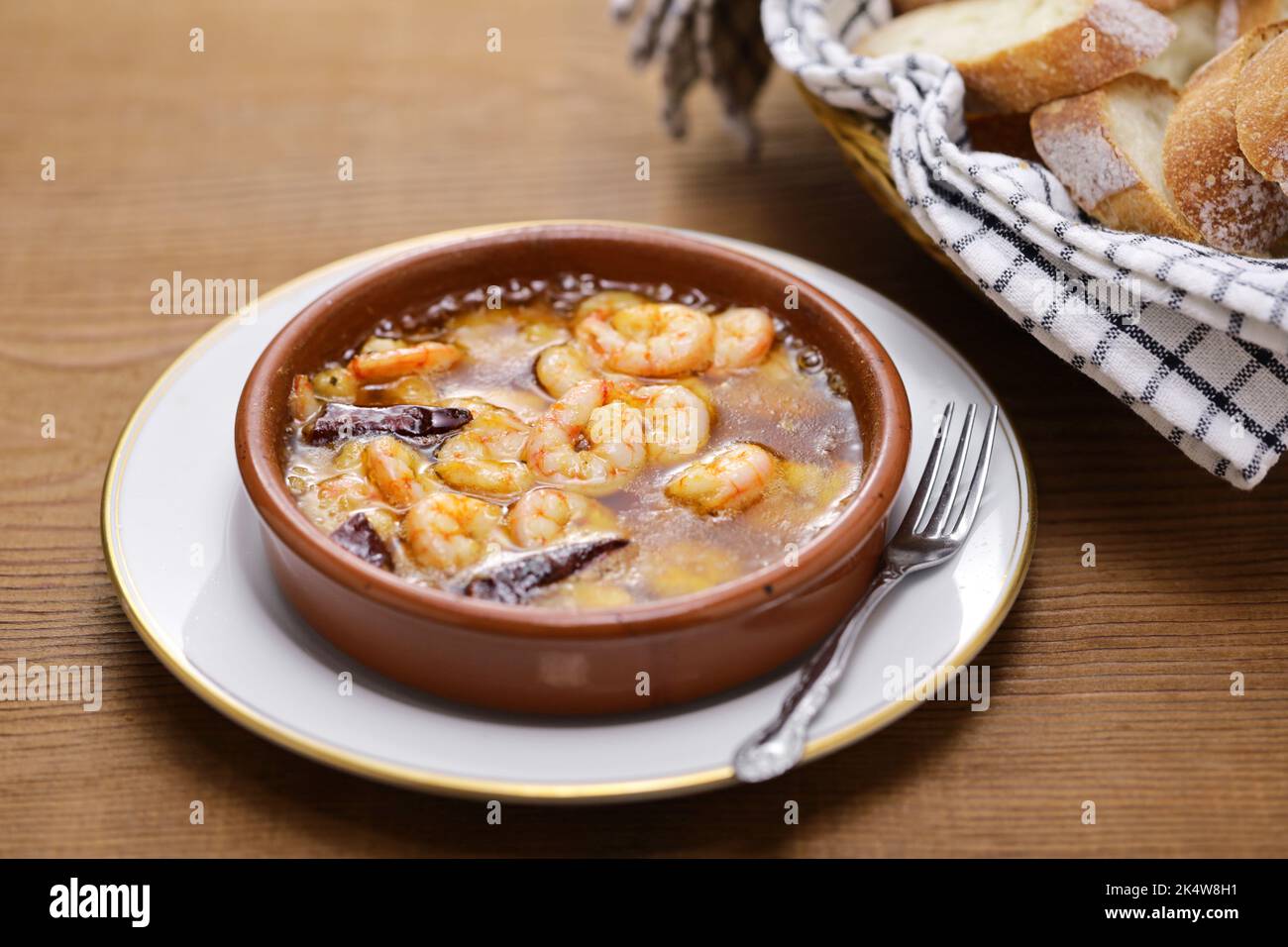 Gambas al Ajillo (A Spanish tapas) ; a cazuela poured with olive oil ...