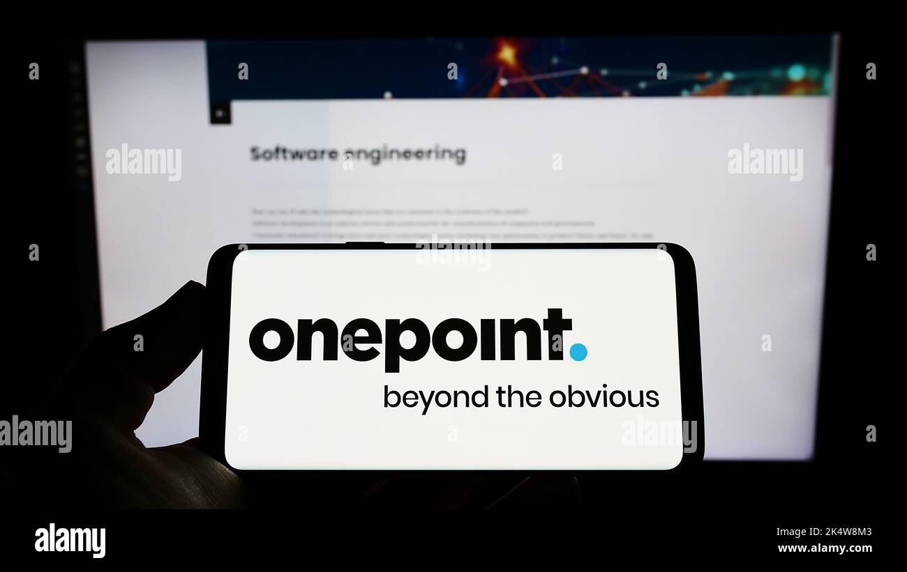 Person holding cellphone with logo of French consulting company ...