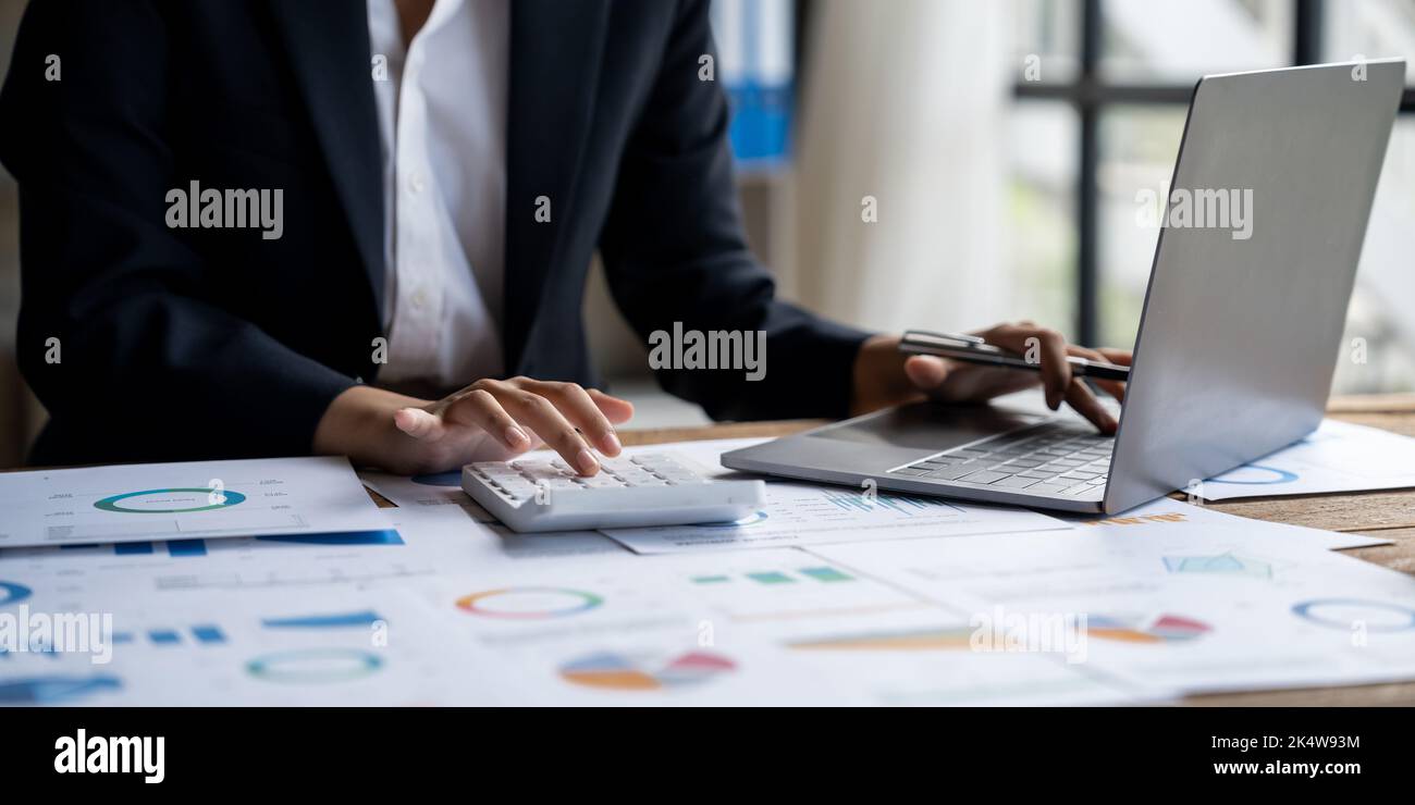 Accountants work analyzing financial reports on a laptop at his office ...