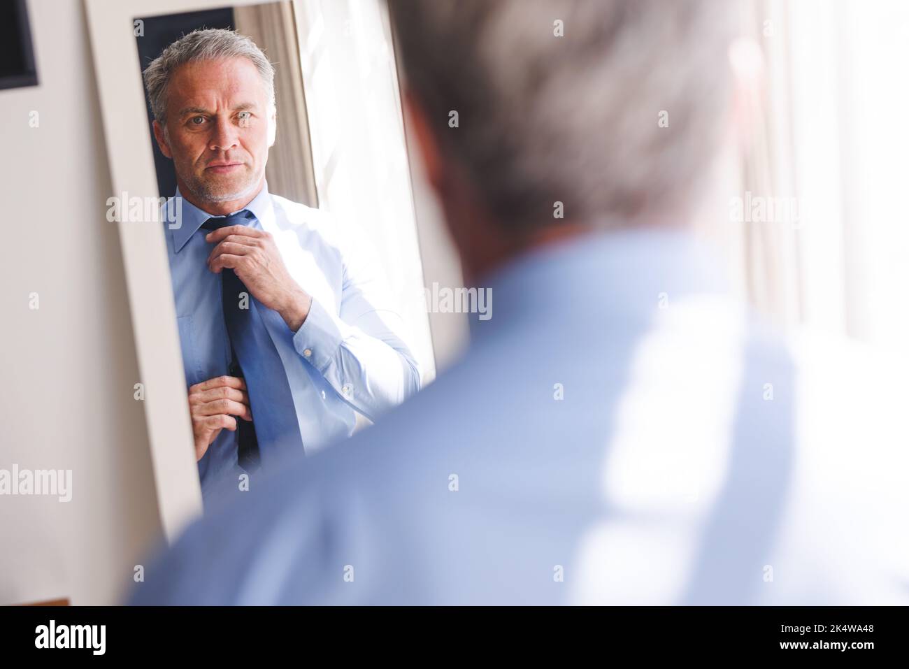 Happy caucasian man standing in bedroom, tying a tie Stock Photo - Alamy