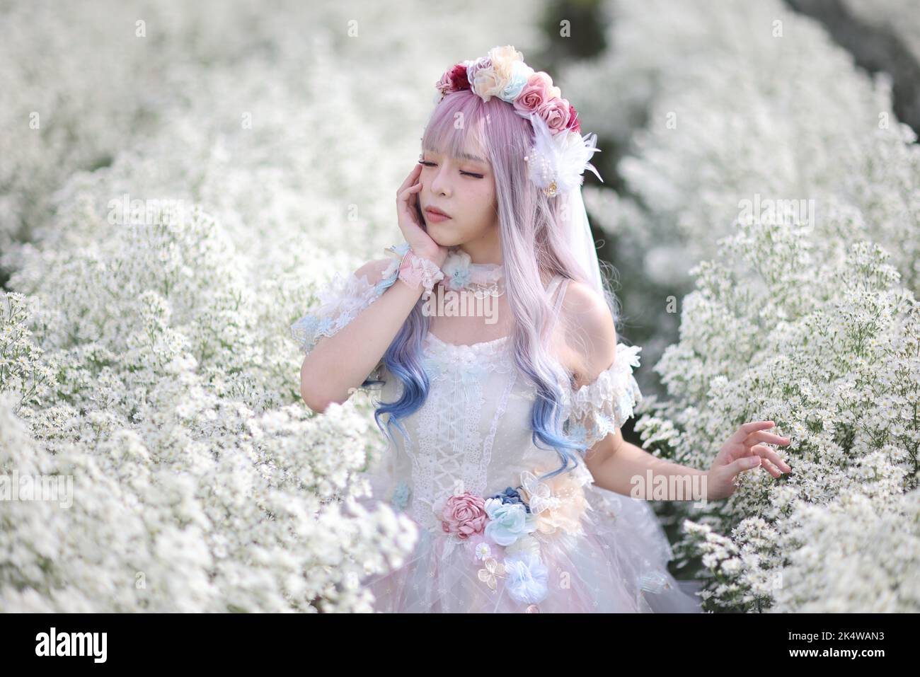 Beautiful young woman with white lolita dress with flowers garden ...