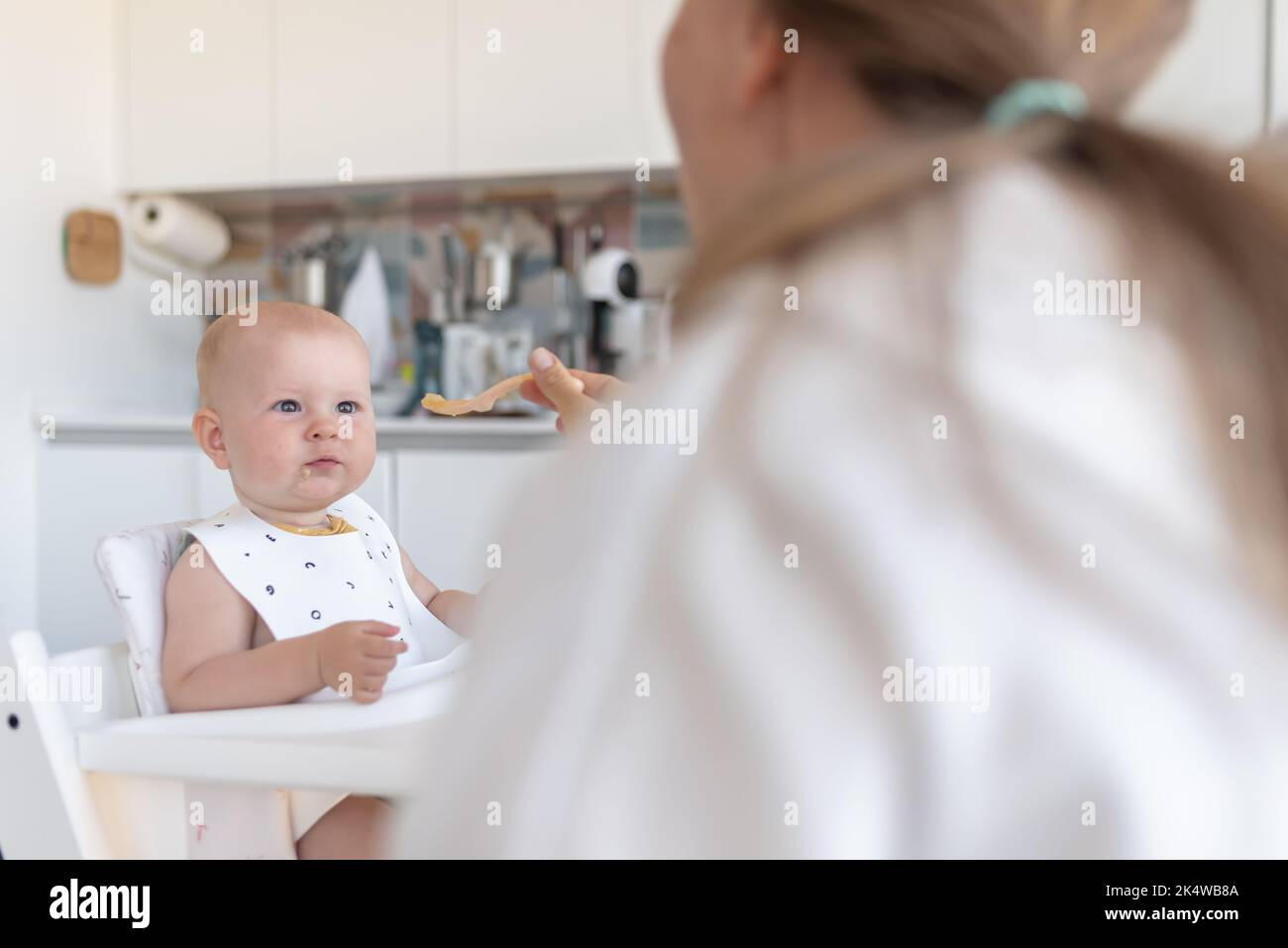 baby's first feeding, mom feeds a baby with a spoon Stock Photo - Alamy